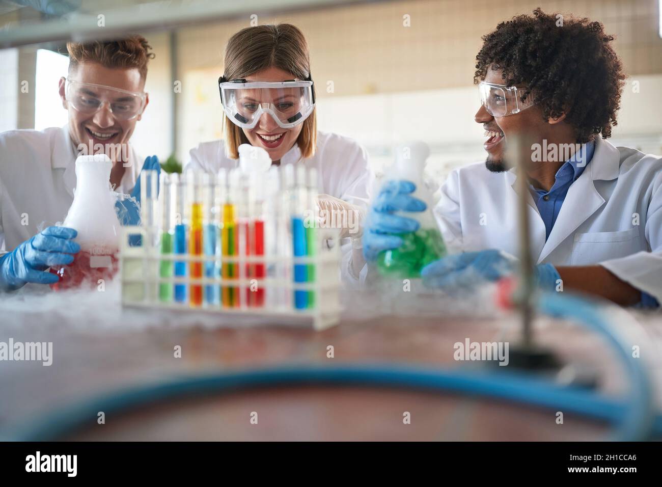 Very happy lab technicians looking biochemical reaction Stock Photo - Alamy