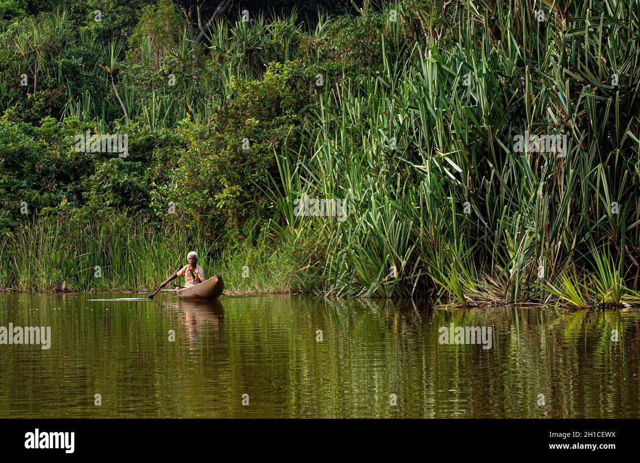 A native male rowing the traditional boat going fishing in the evening ...