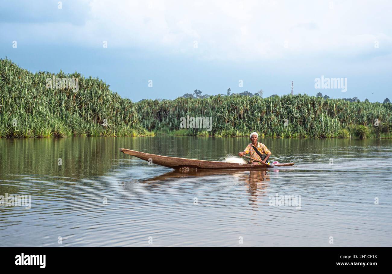 A native male rowing the traditional boat going fishing in the evening ...