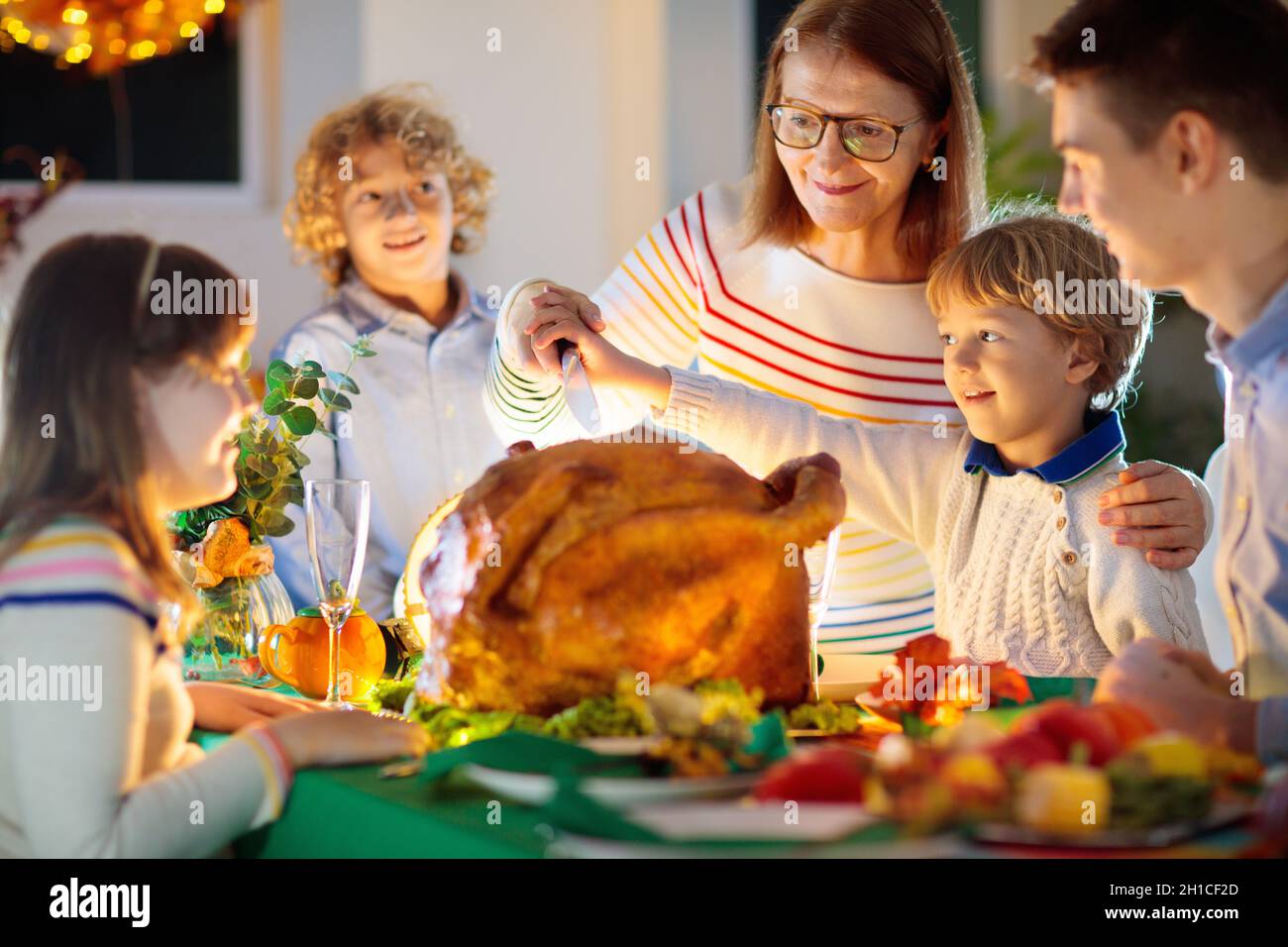 Family at Thanksgiving dinner. Parents, grandparents and kids enjoy ...