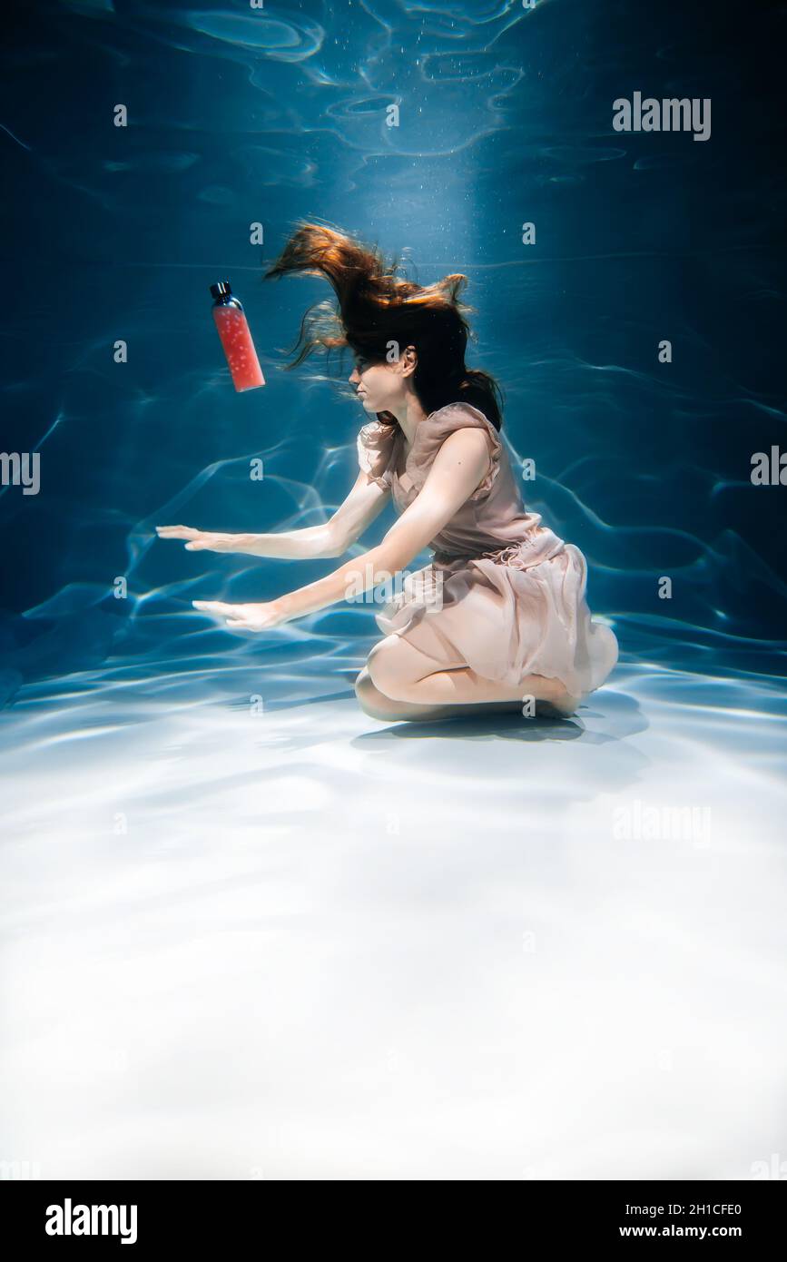 Fitness girl with colorful smoothie. Freshness under water, swims and ...