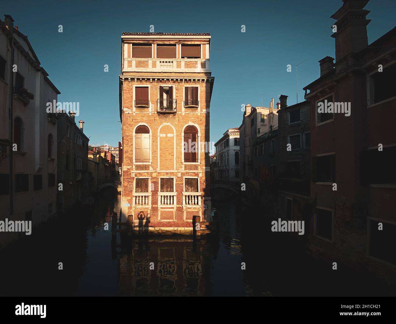 Beautiful and colorful venetian front house surrounded by water during ...