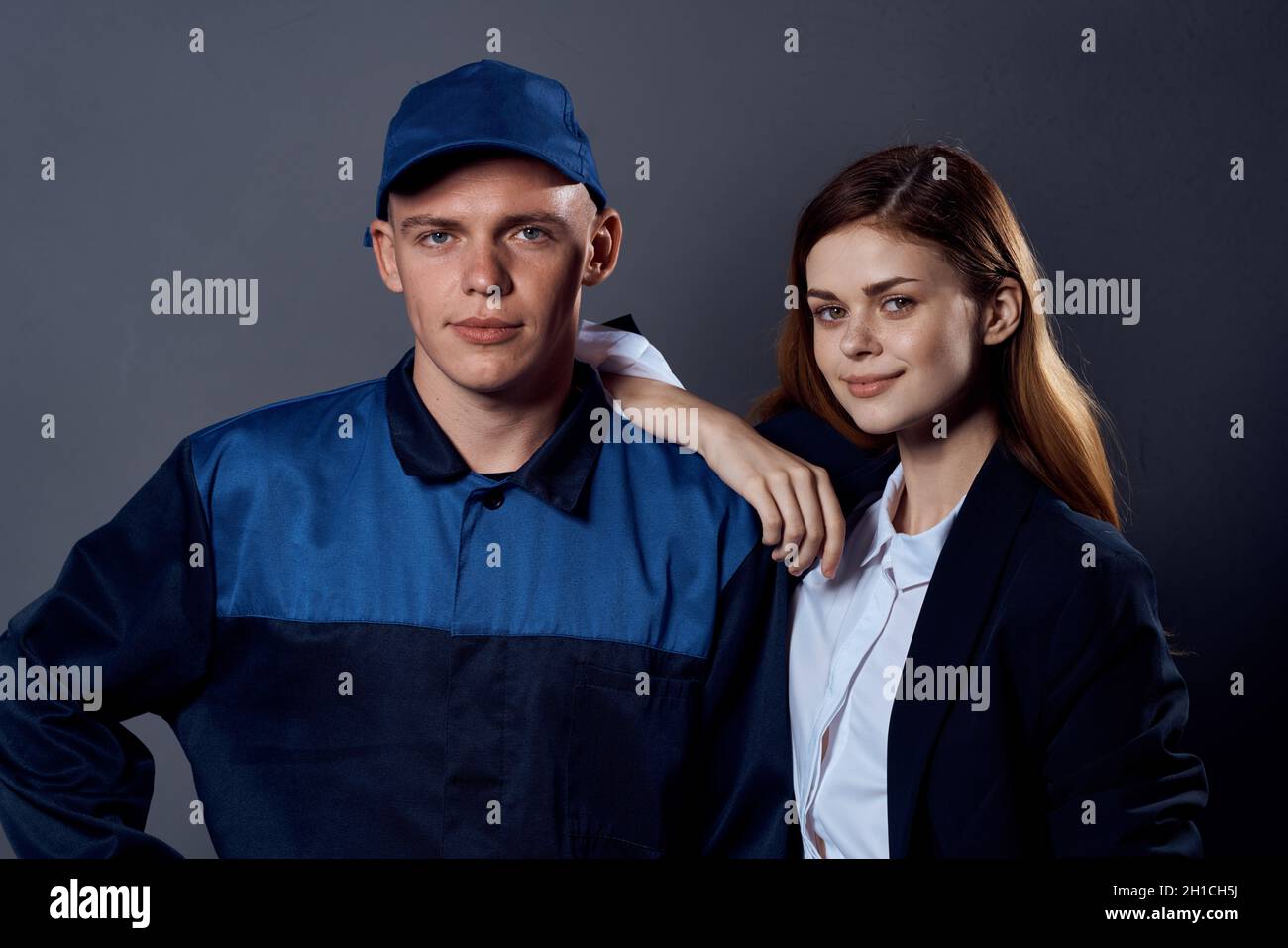 a man in a working uniform next to a woman in a suit office work team ...
