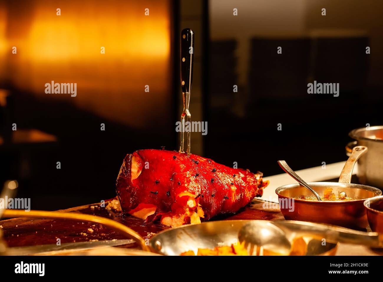 Roasted red pork leg with spices, pepper, meat fork in modern ...