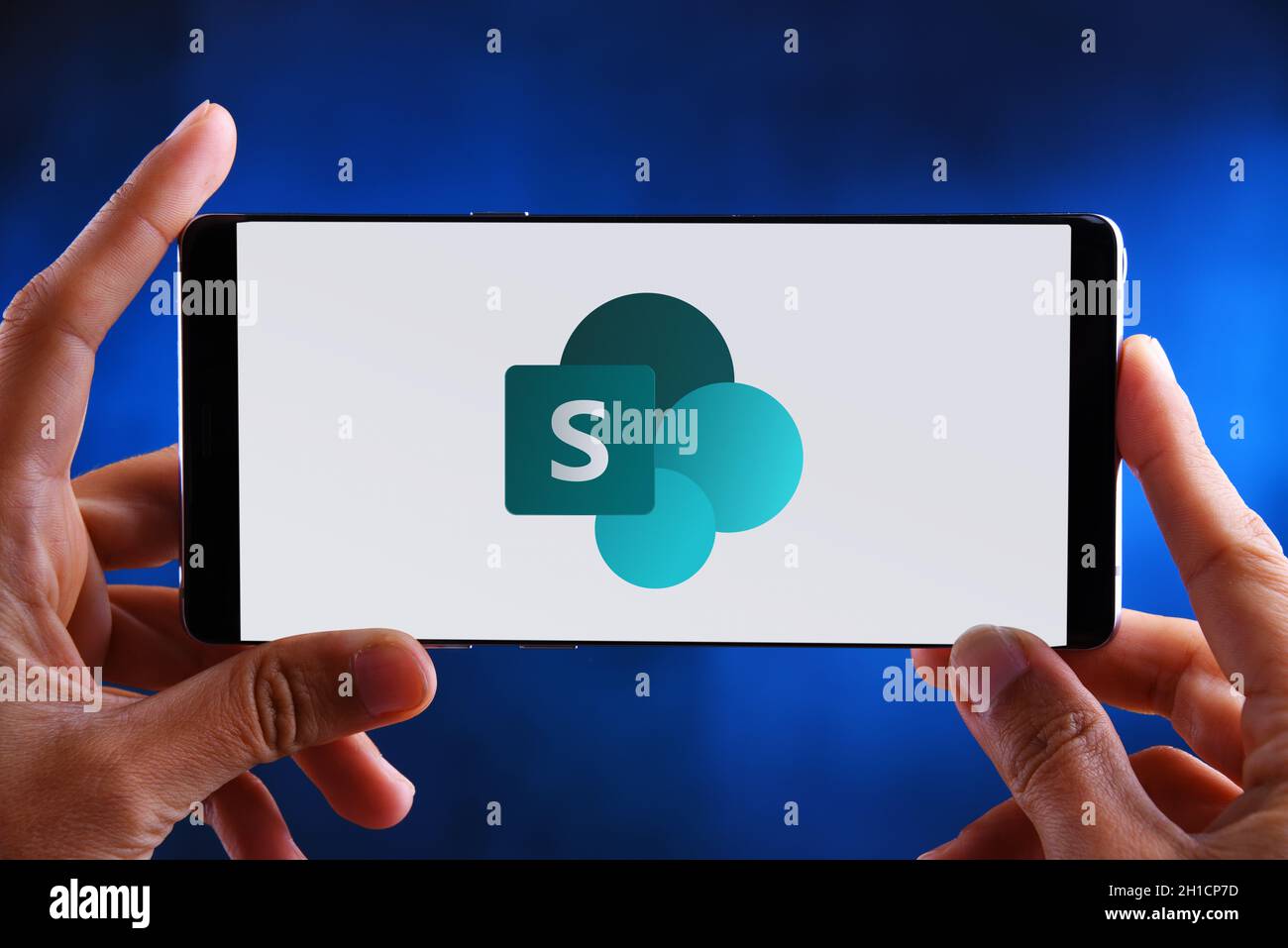 POZNAN, POL - FEB 19, 2020: Hands holding smartphone displaying logo of ...