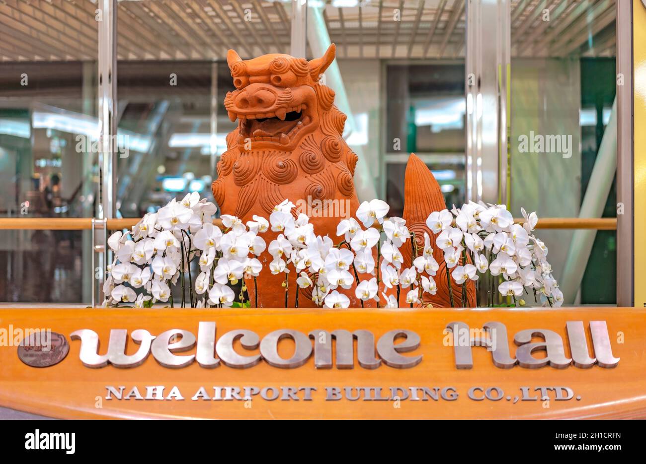 Japanese Okinawan lion Shisa sculpture decorated with white orchids ...