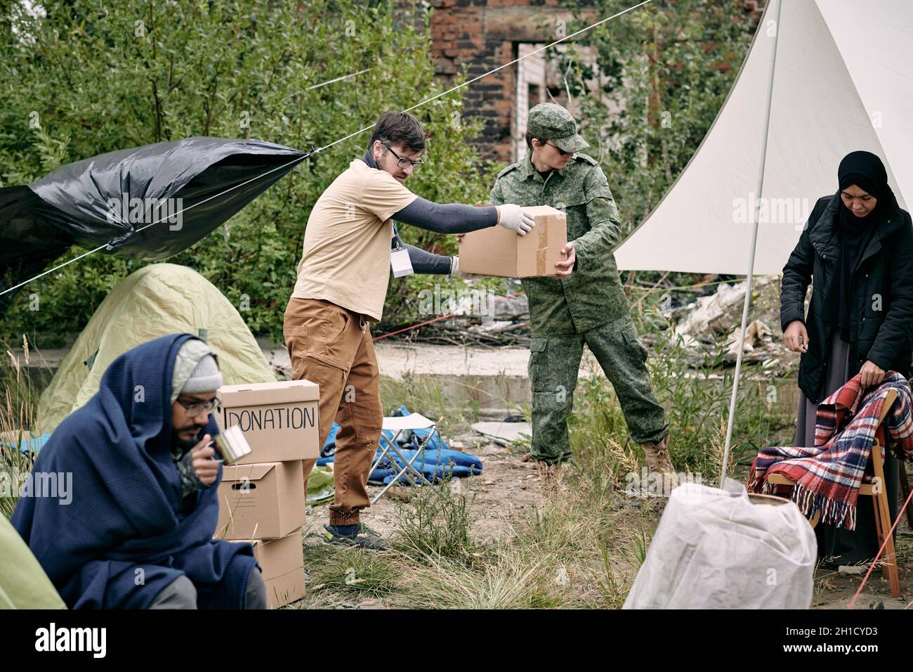 Young volunteer and representative of migration service spreading ...