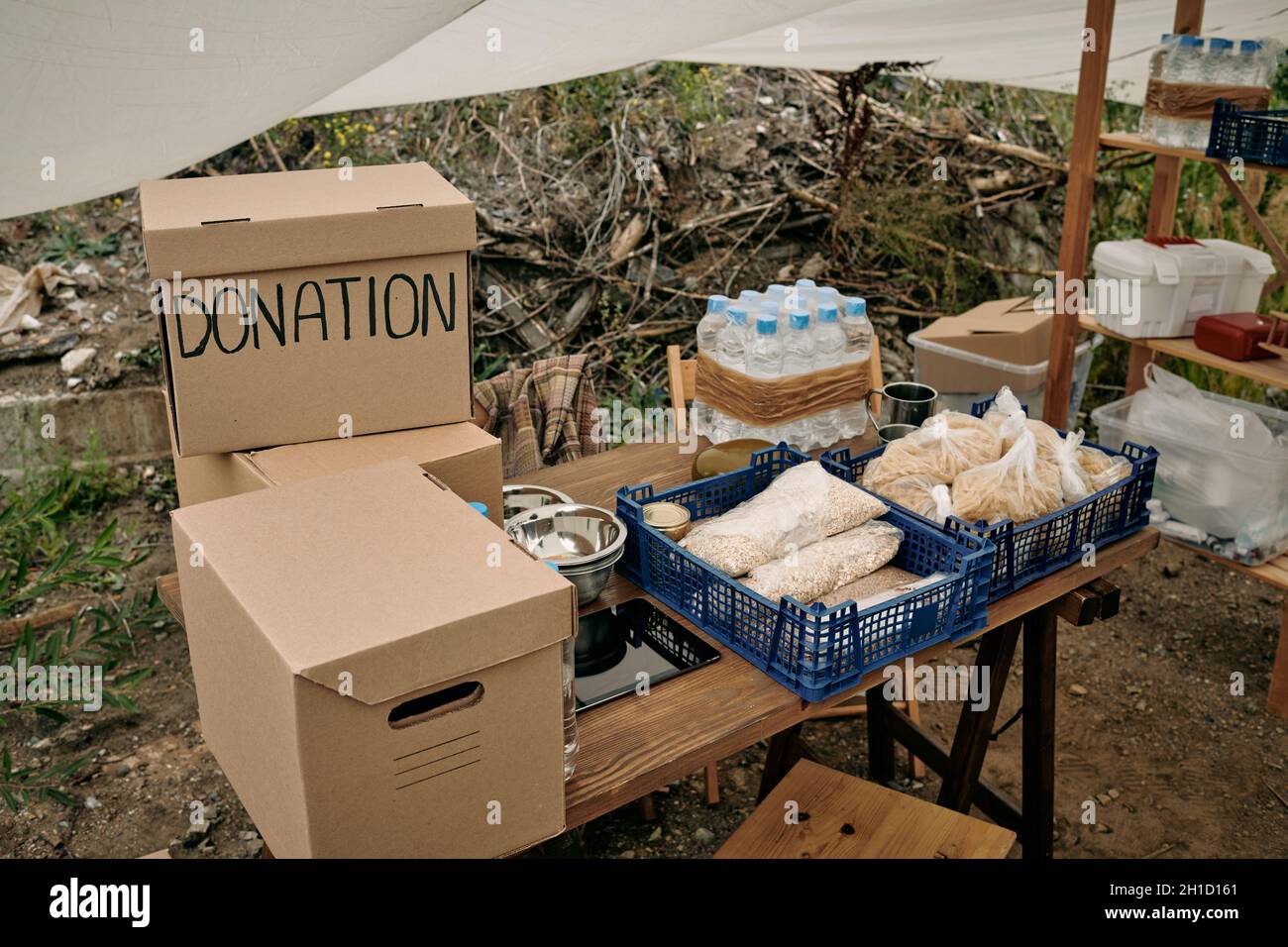 Packed boxes with clothes and donation food on wooden table in large ...