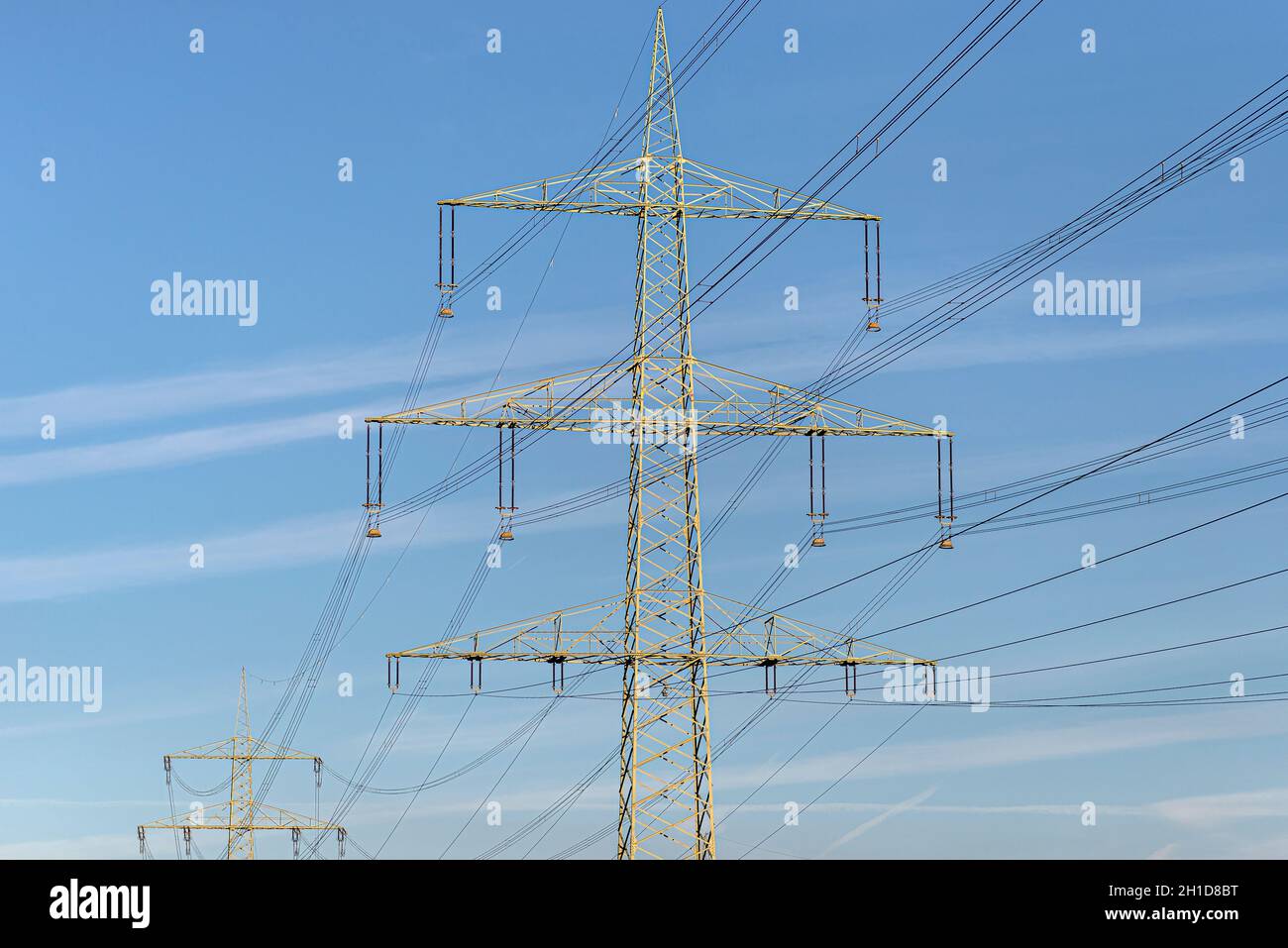 Power lines and pylons for transmission of electricity, against a blue ...