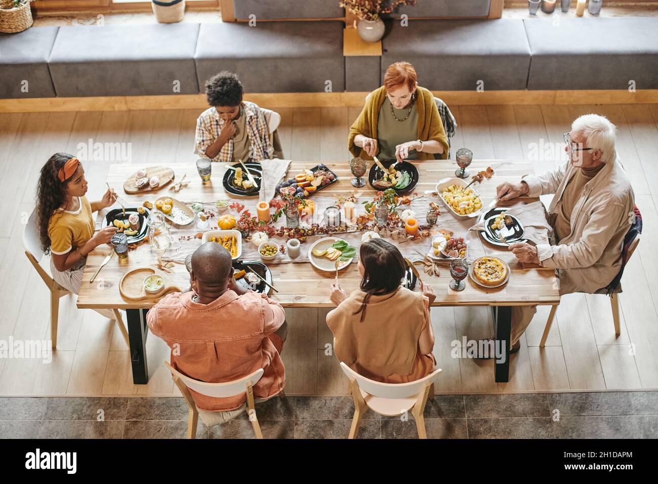 High angle view of big family sitting at dining table and having dinner ...