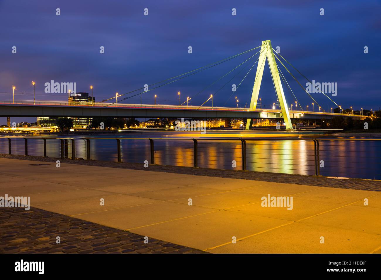 Tranquil scenery of a bridge in city lights at night in Cologne ...