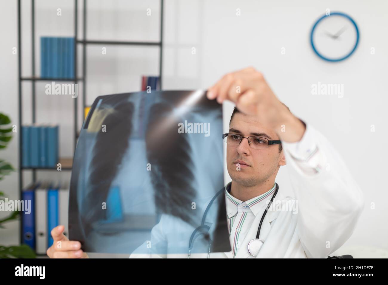 In a hospital office, a pulmonology physician checks a patient's lung x ...