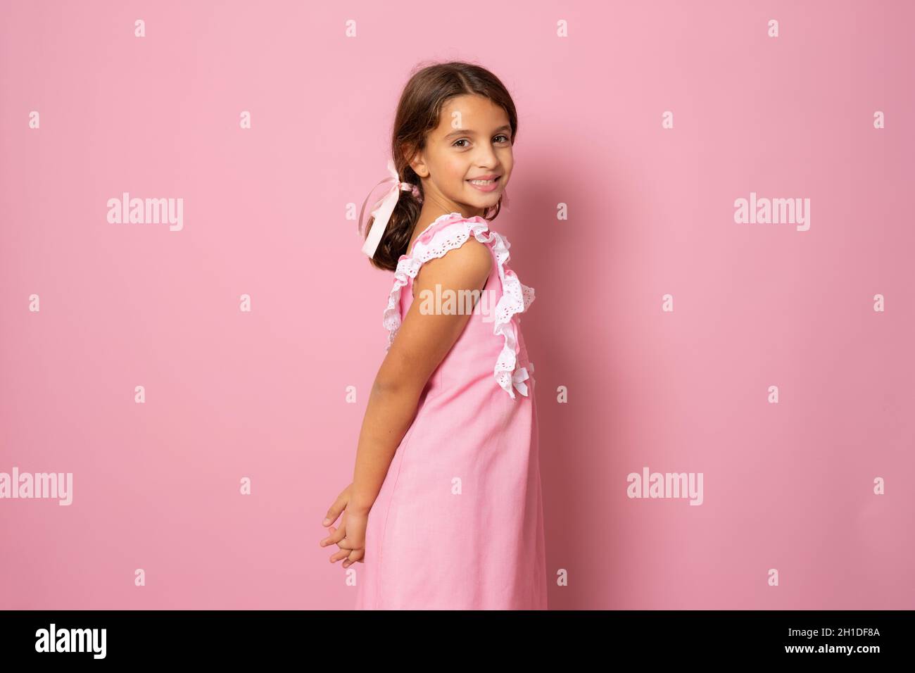 Portrait of beautiful little girl wearing pink dress posing isolated ...
