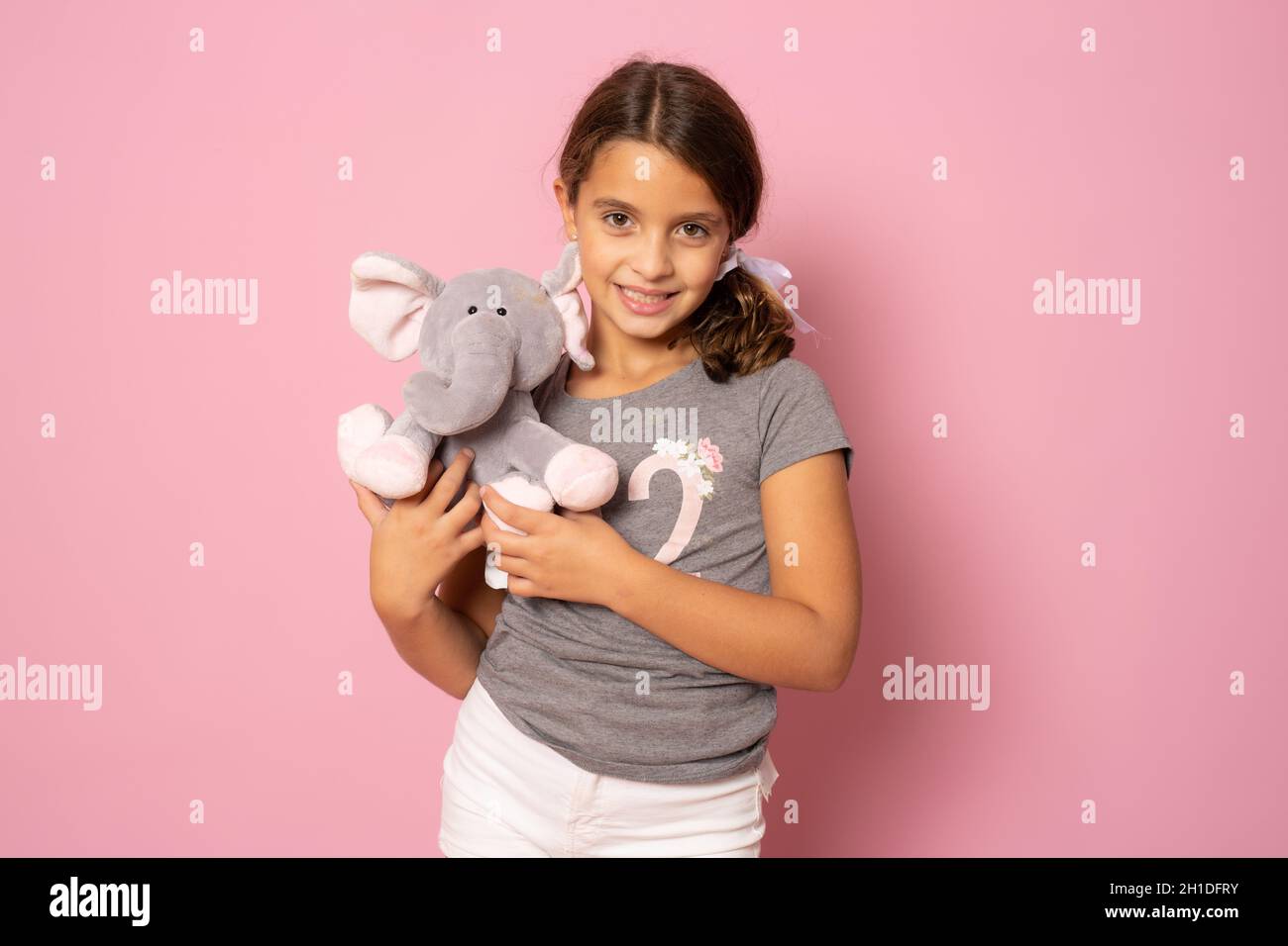 childhood, toys and people concept - cute little girl hugging elephant ...