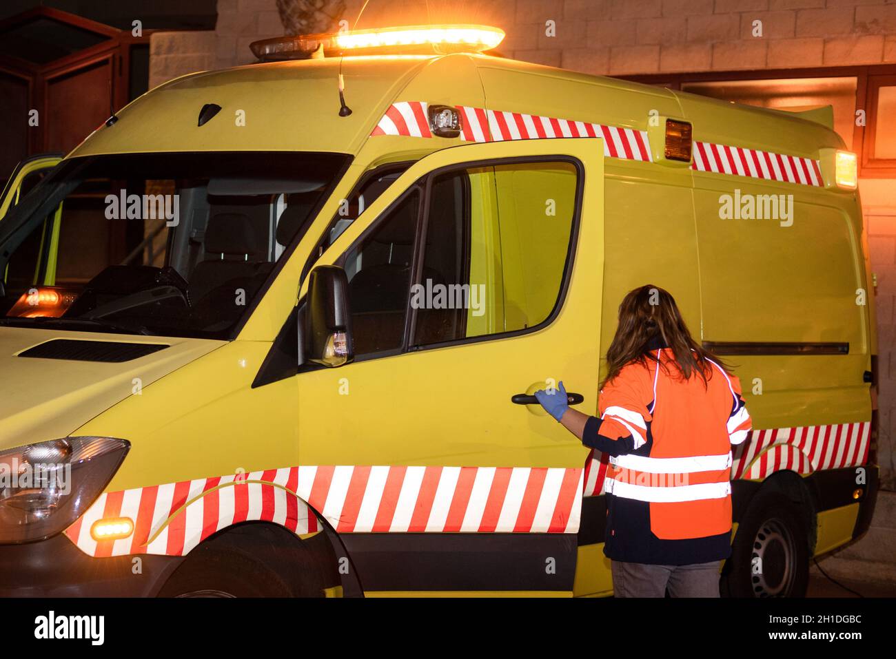 Night scene of an unrecognizable Paramedic, Ambulance woman driver at ...