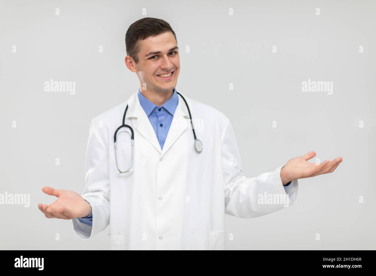 The smiling doctor spreads his arms from side to side and leaves the ...