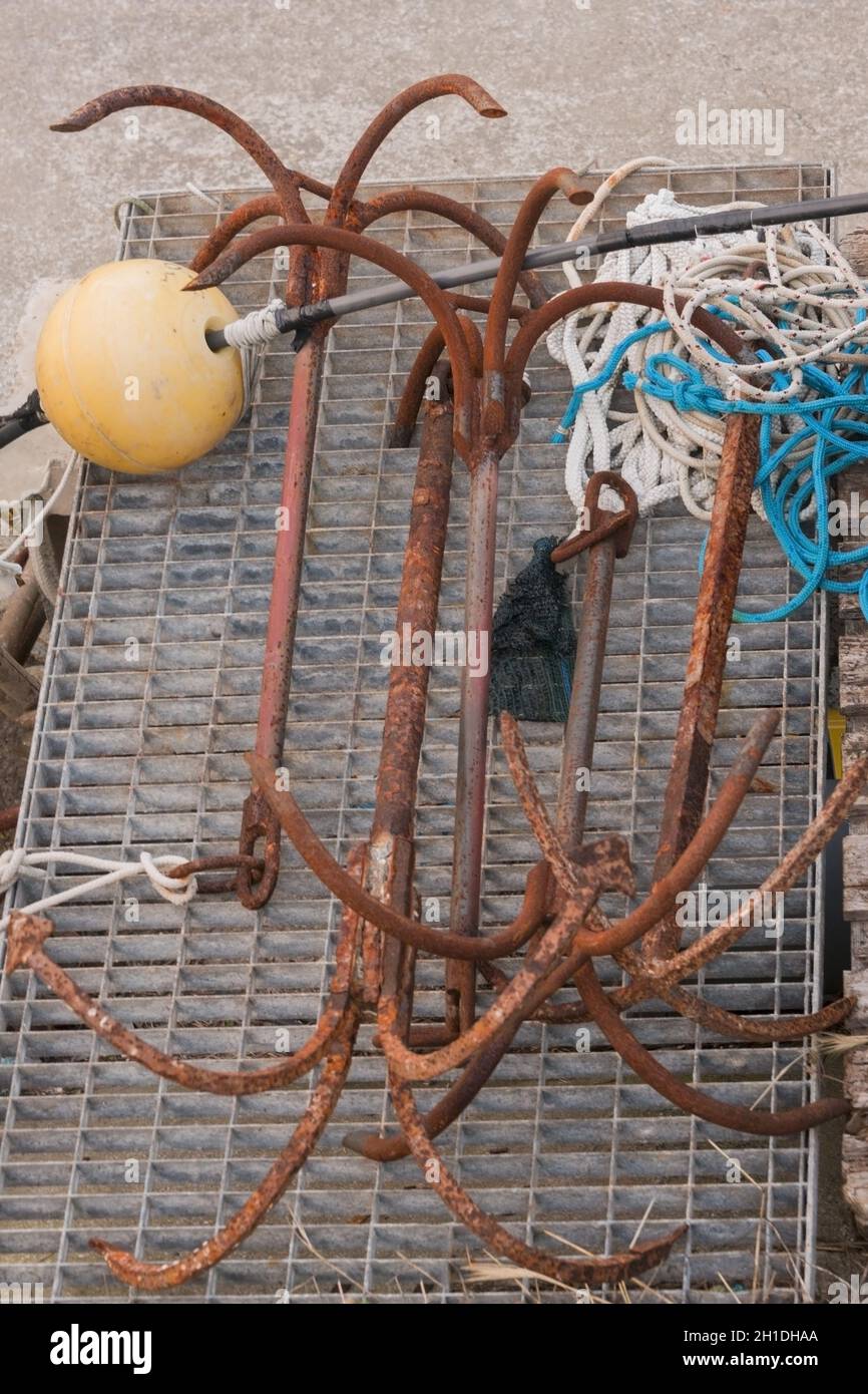 Rusty anchors, ropes and a buoy on metal slatted frame Stock Photo - Alamy