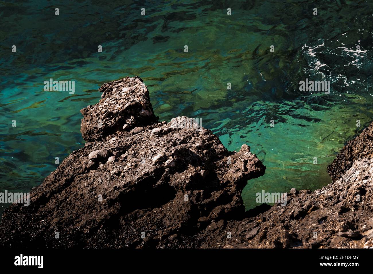 Eerie scenery of a cliff by the azure clear ocean Stock Photo - Alamy