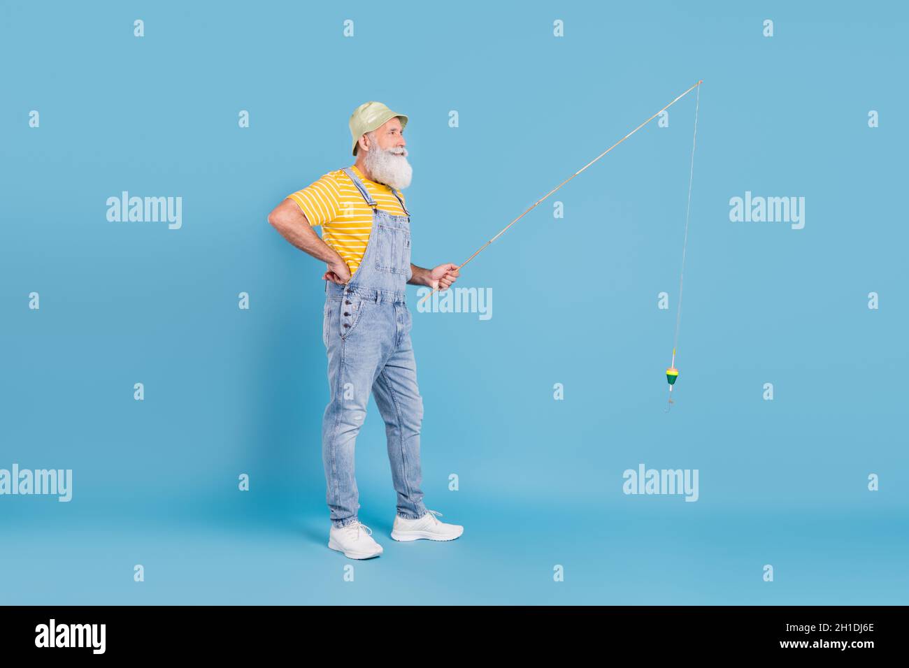 Full size profile side photo of aged man fishing hold spinning rod look ...