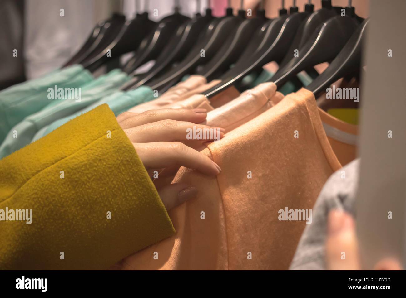 Shopping in big store, hangers with clothes, fashion background Stock ...