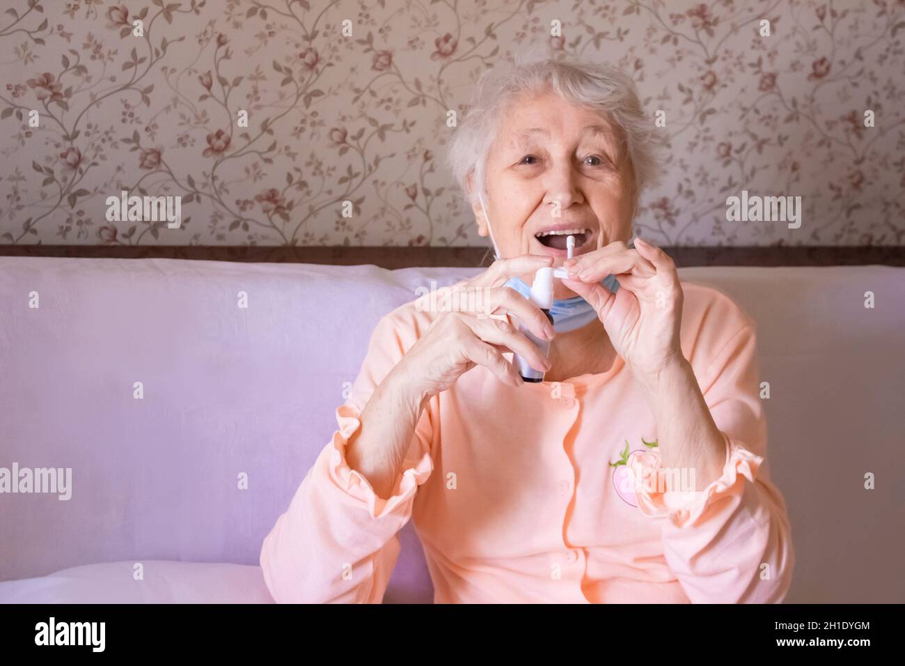 Senior sick old woman using cough spray at home Stock Photo - Alamy