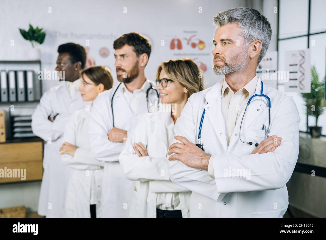 Side view of multiracial group of doctors posing in line at hospital ...