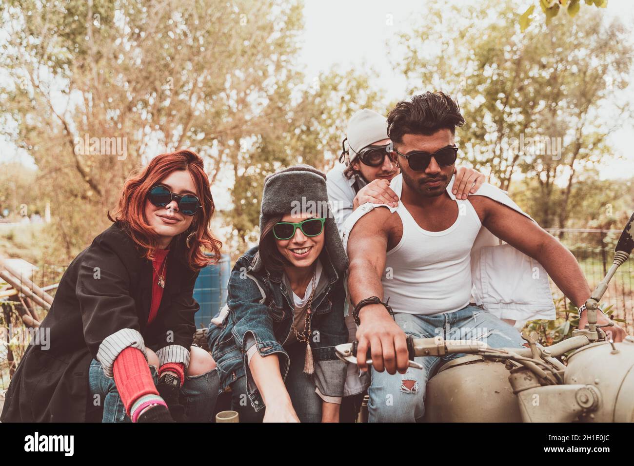 group of best friends together have fun riding a vintage motorcycle ...