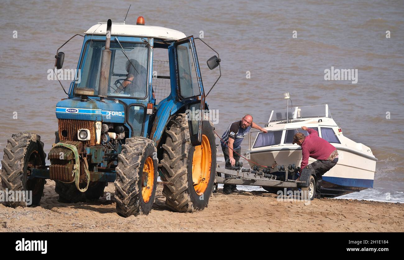 Pulling a fishing boat from the sea onto tractor drawn trailer. Hornsea ...