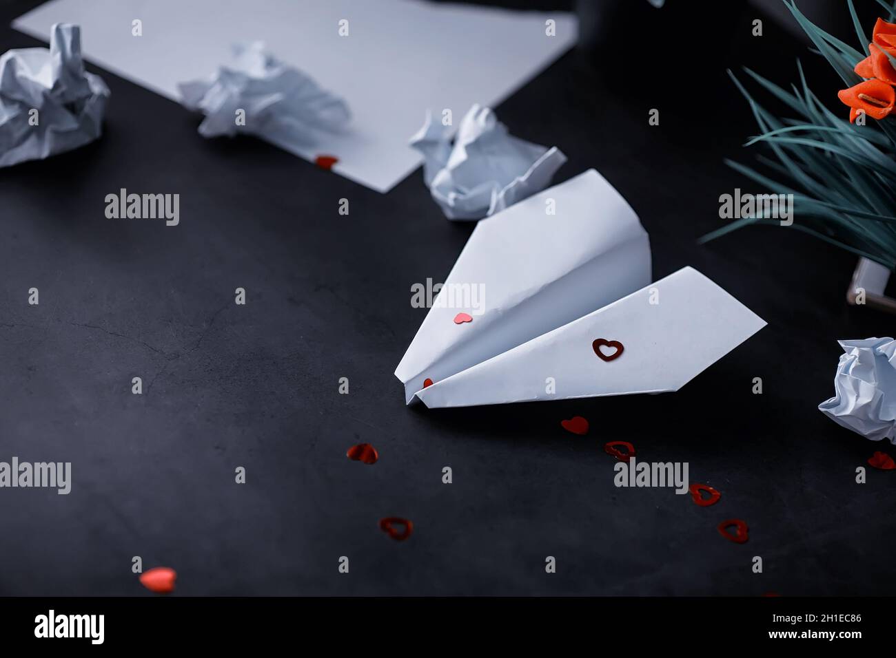 Paper airplane on the table. Origami model on a dark background ...