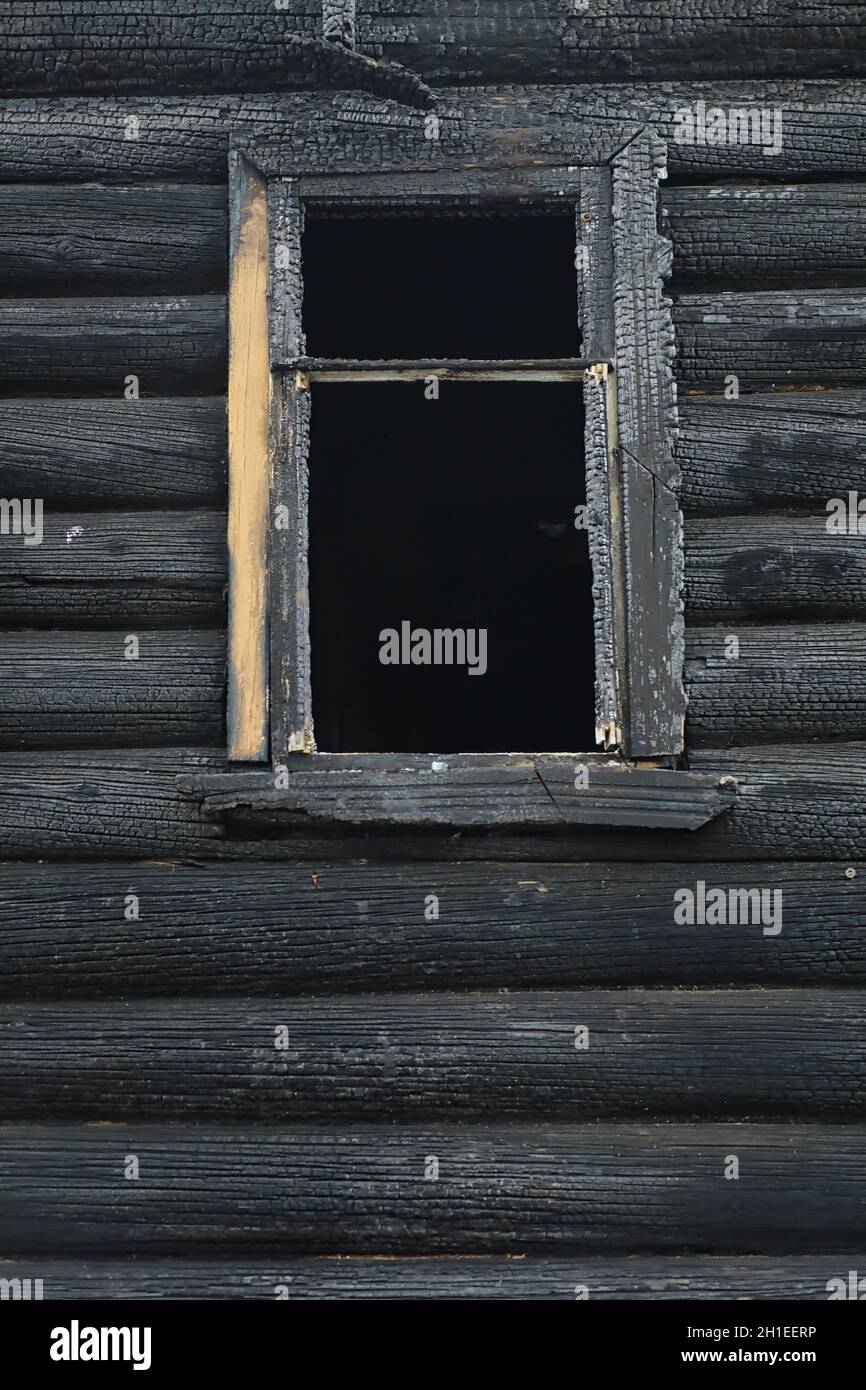 Wooden house after the fire. Coals on the logs. The ashes of the house ...