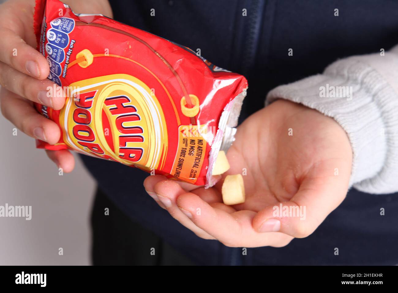 pouring Hula Hoops into boys hand Stock Photo - Alamy