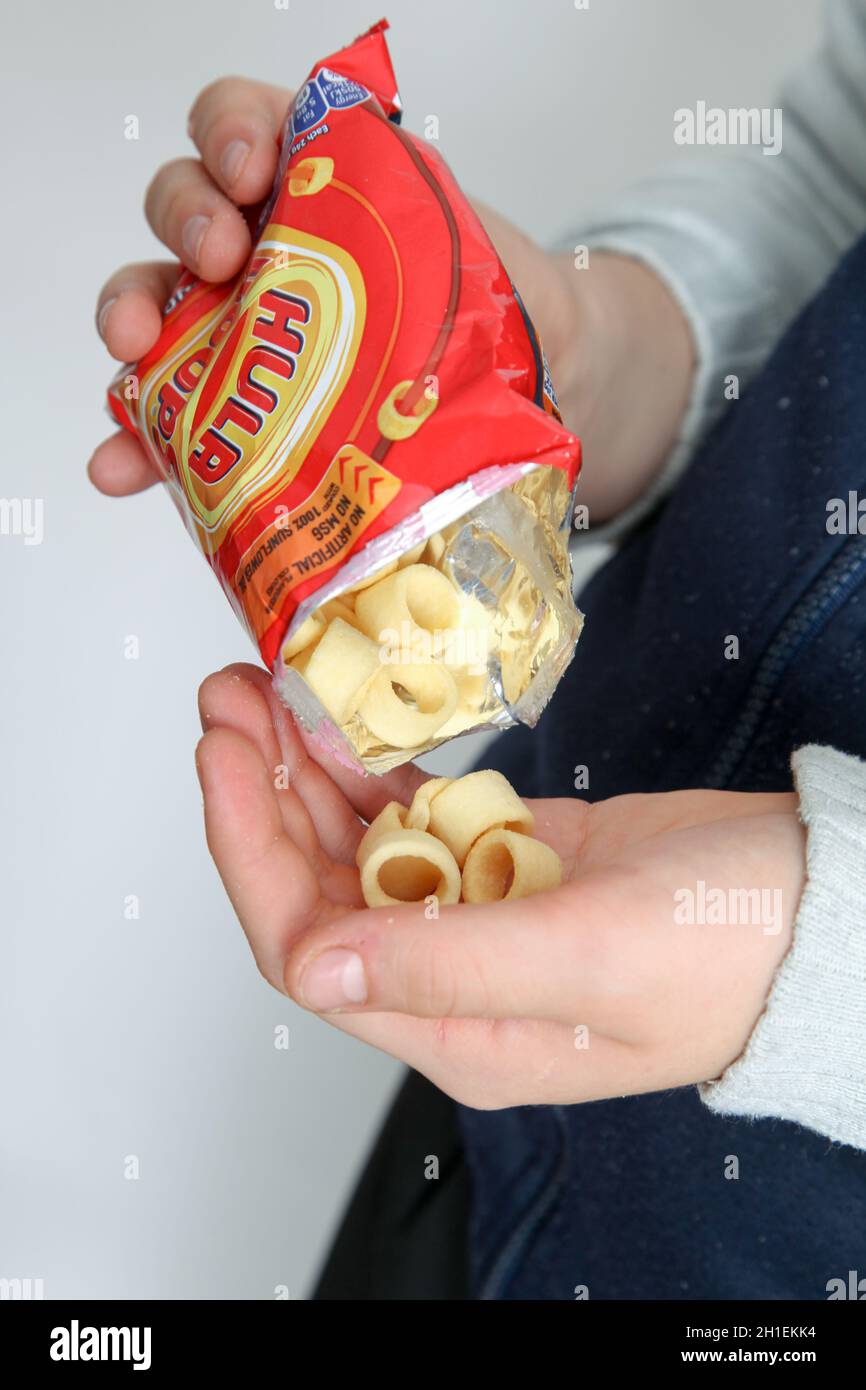 Pouring Hula Hoops into boys hand Stock Photo - Alamy