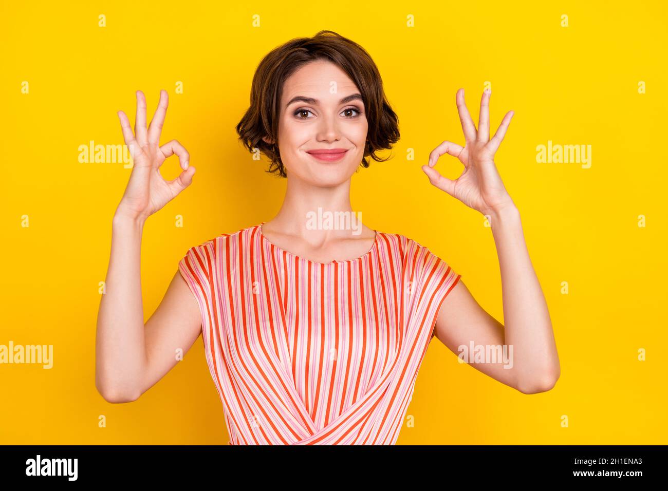 Portrait of attractive cheerful girl showing double ok-sign ad solution ...