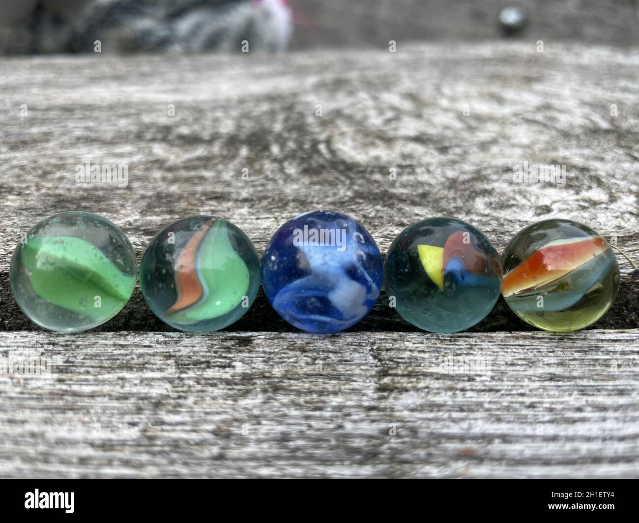 Closeup shot of beautiful and colorful marble balls on the wooden ...