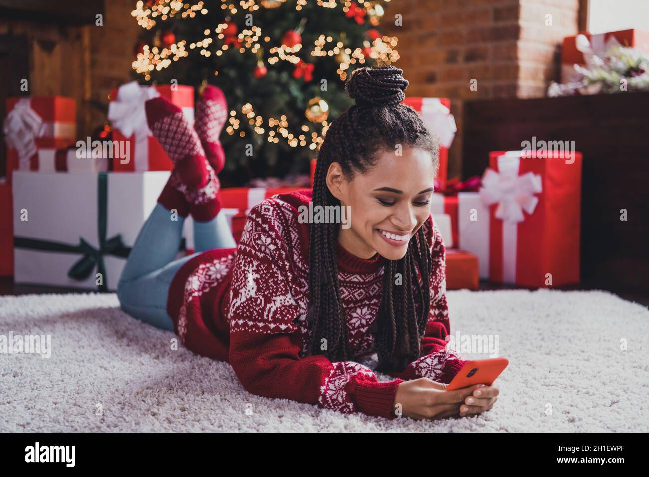 Photo of cheerful lady lay carpet hold telephone typing blog post wear pullover in decorated ...