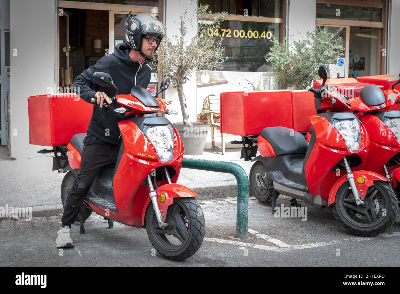 Delivery boy of takeaway on scooter with isothermal food case box ...
