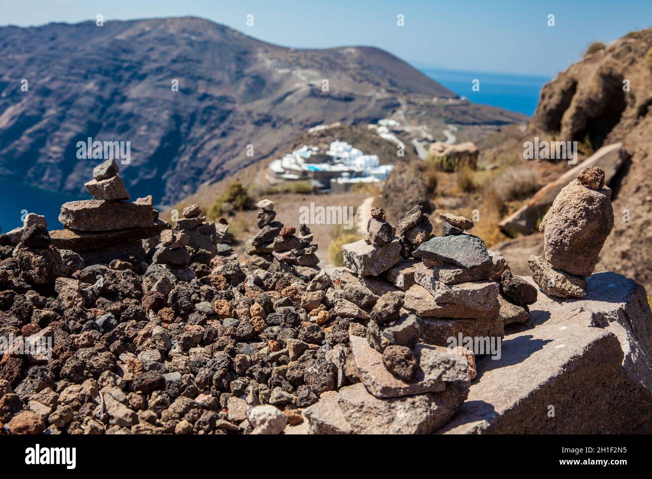 Cairns of rocks at the walking path number 9 between the cities of Fira ...