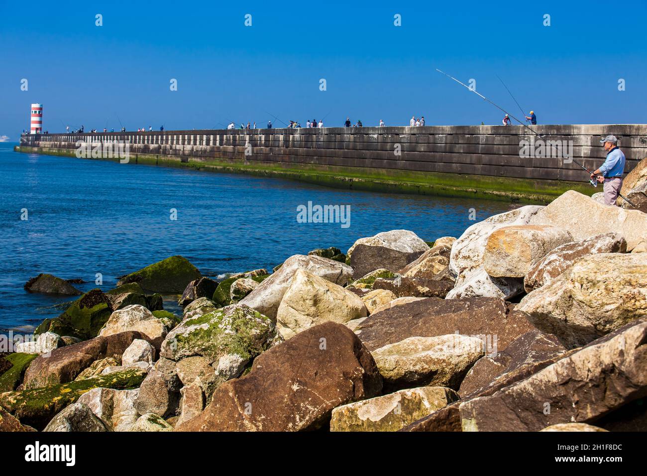 PORTO, PORTUGAL - MAY, 2018: Men fishing at the beautiful Porto coast ...