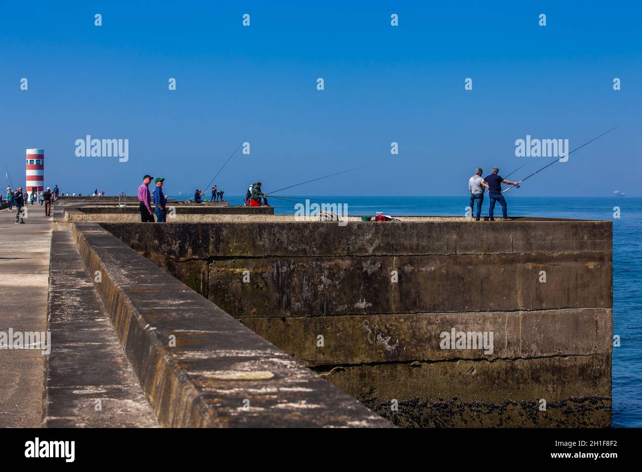 PORTO, PORTUGAL - MAY, 2018: Men fishing at the beautiful Porto coast ...