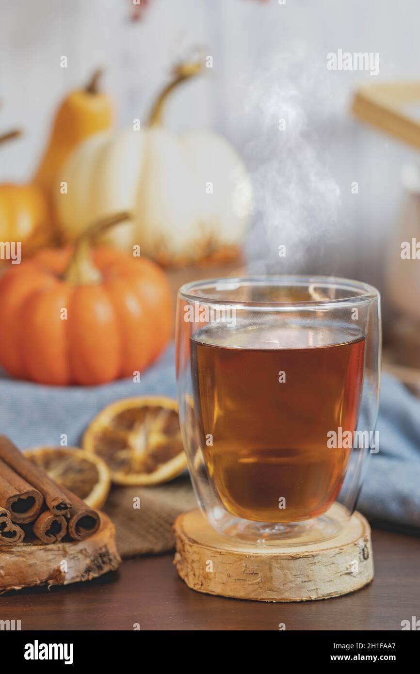 Tea with autumn decor, pumpkins,dry Orange slices and cinnamon on table ...