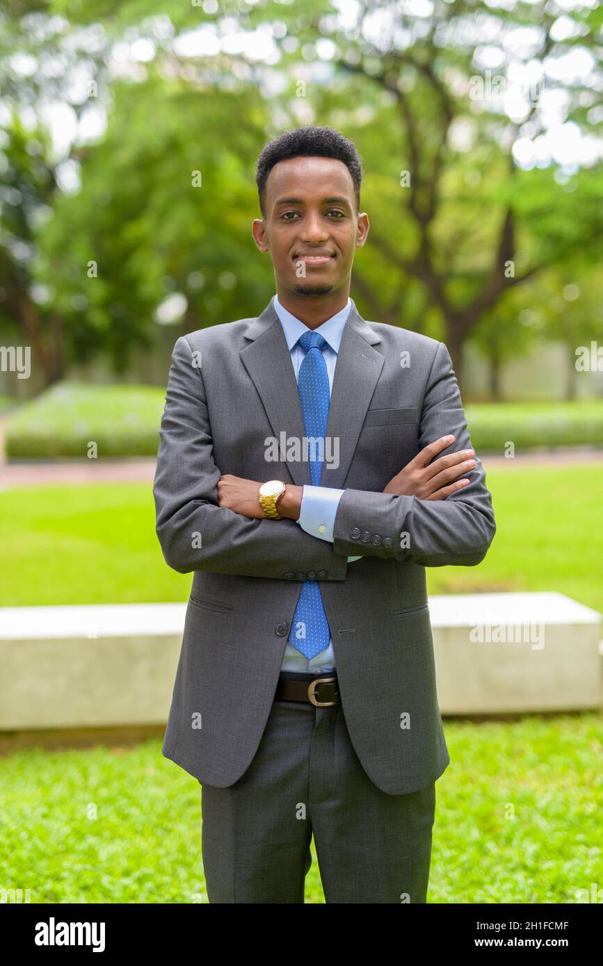 Portrait of handsome young African businessman wearing suit and tie ...