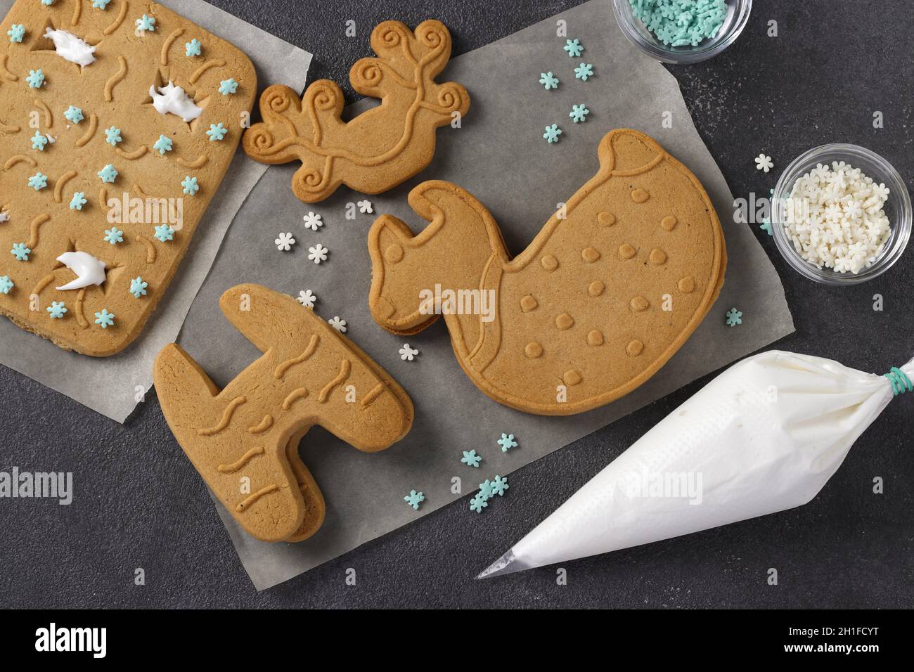 Build deer-shaped gingerbread at home. Step by step. Top view on dark ...
