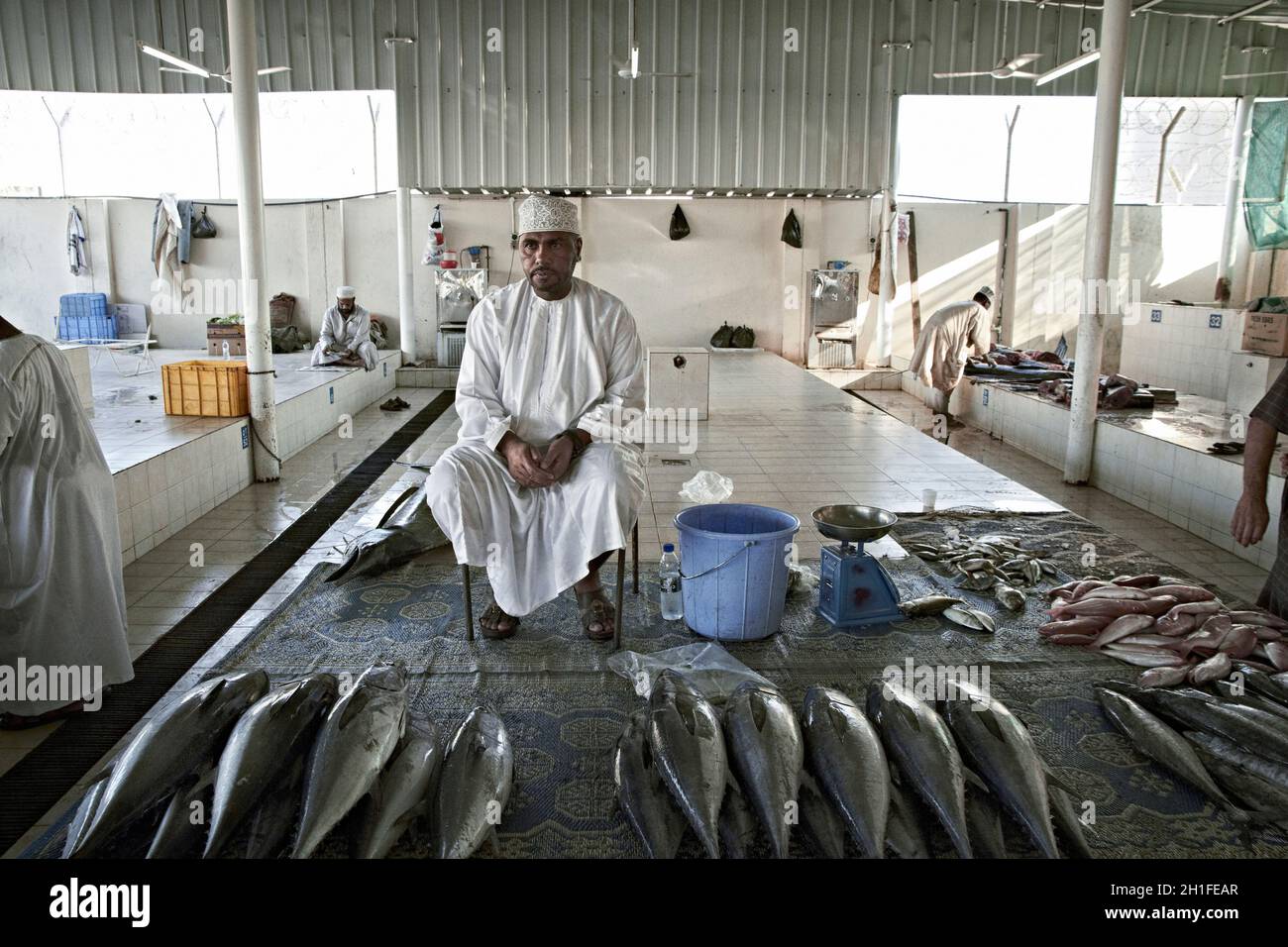 Old omani fisherman selling his catch at the old fish market in Muttrah ...