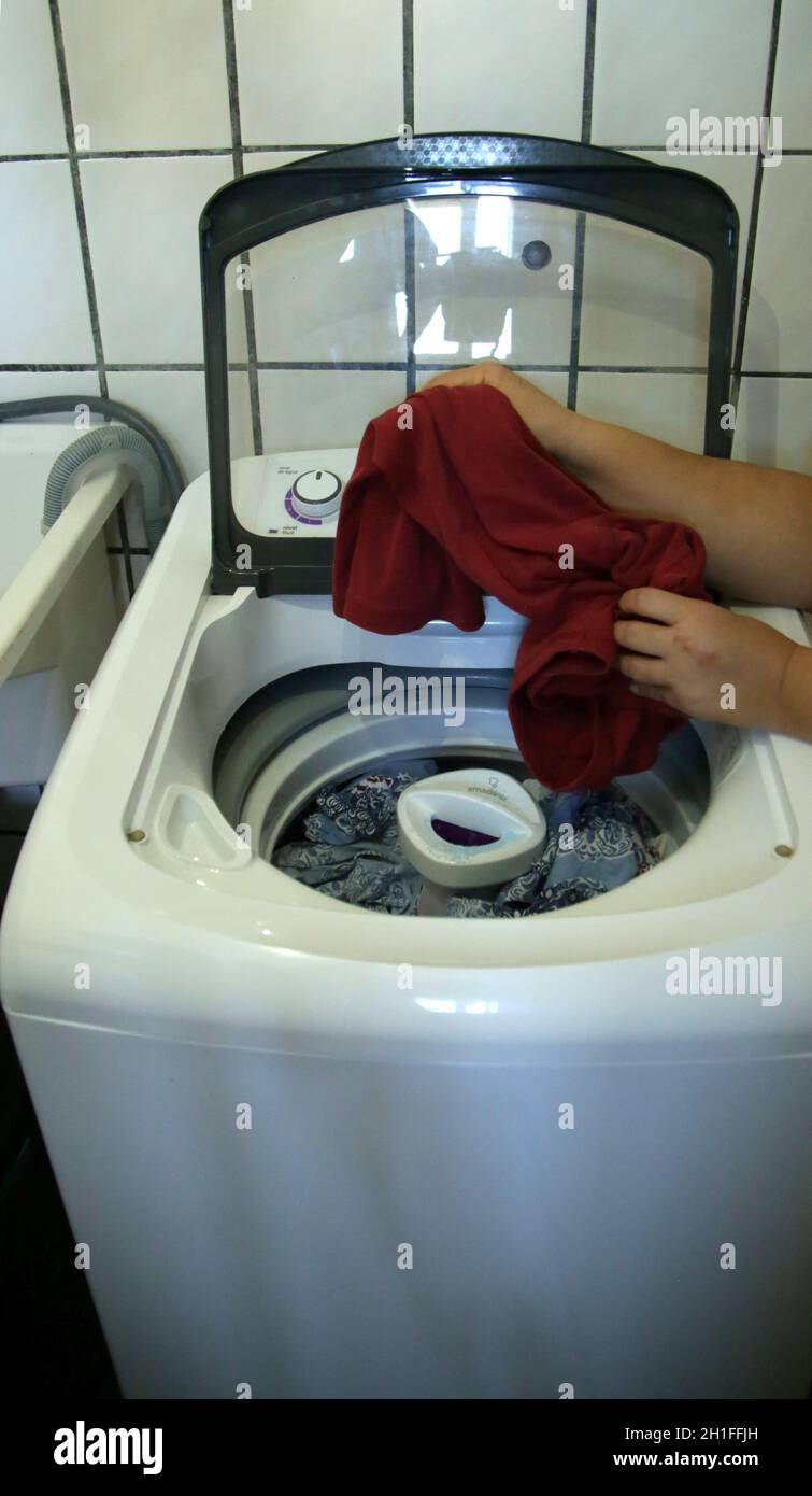 salvador, bahia / brazil - may 24, 2020: hand is seen putting washing ...