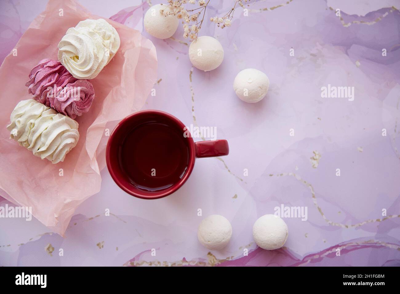Delicate pink and white marshmallow with decoration and cup of tea. Top ...