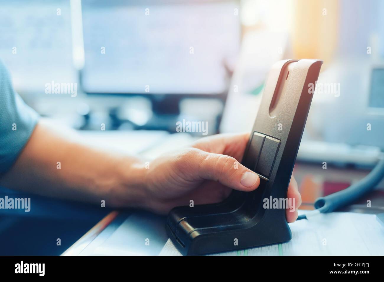 The dispatcher answers the call. The dispatcher's hand presses a button ...