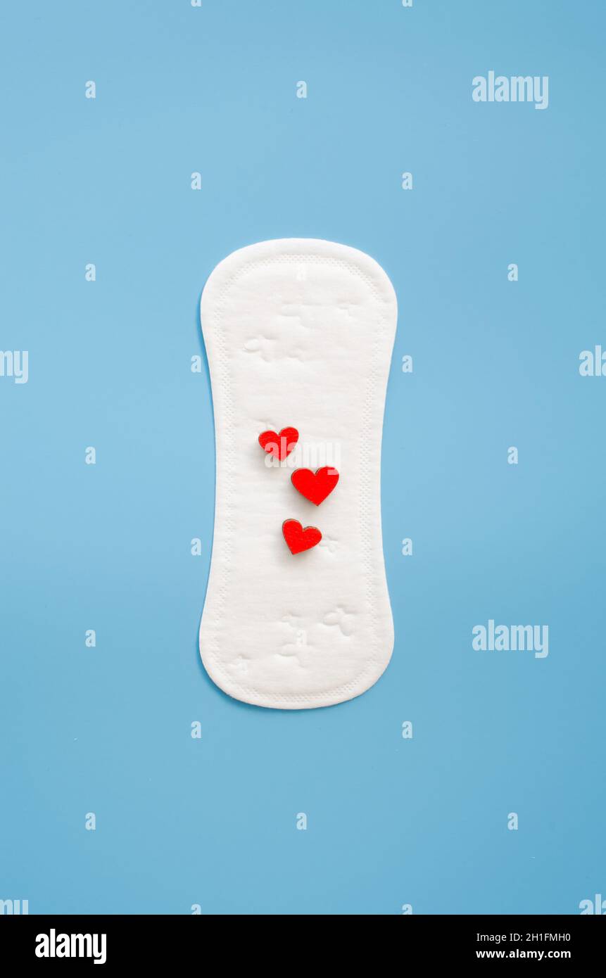 Feminine hygiene pad with red heards on blue background. Imitation of ...