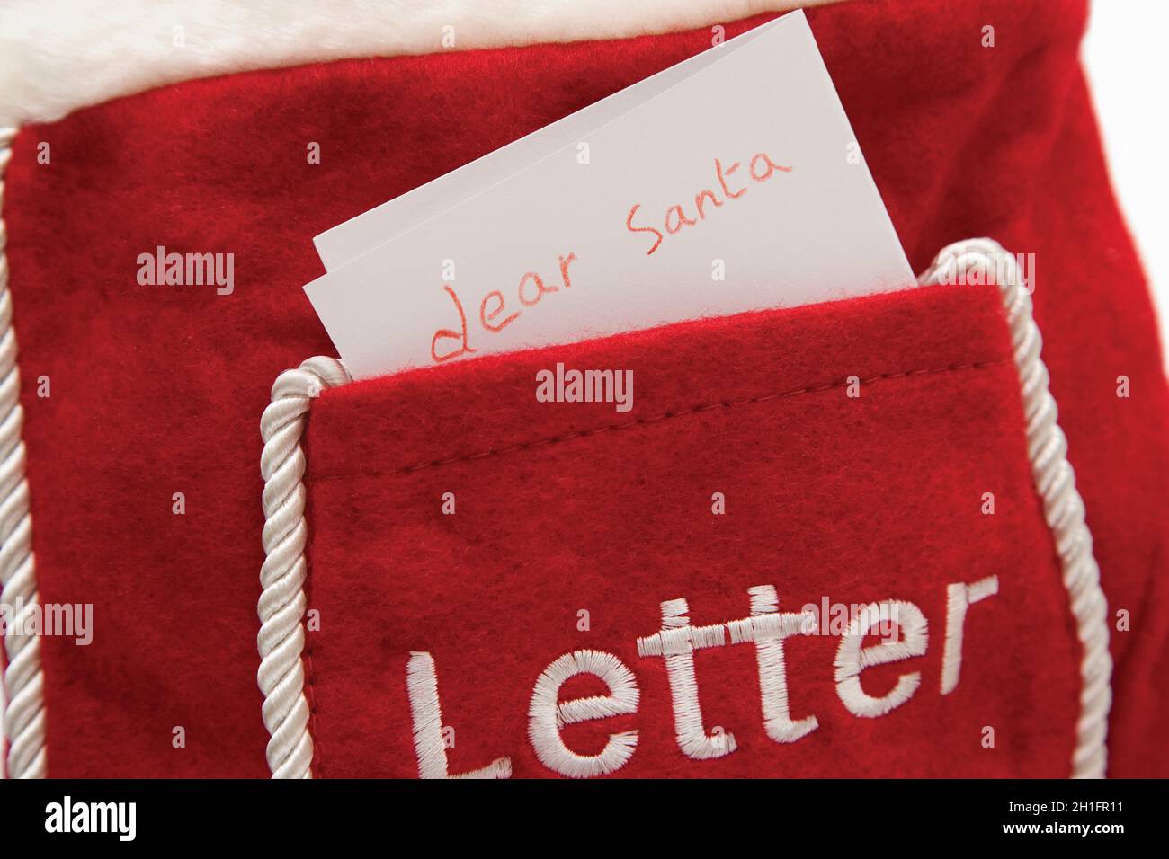 Red Christmas stocking with a letter to Santa in the front pocket Stock ...