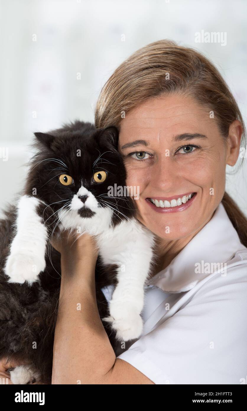 Veterinary hugging a cat and reassuring for review Stock Photo - Alamy