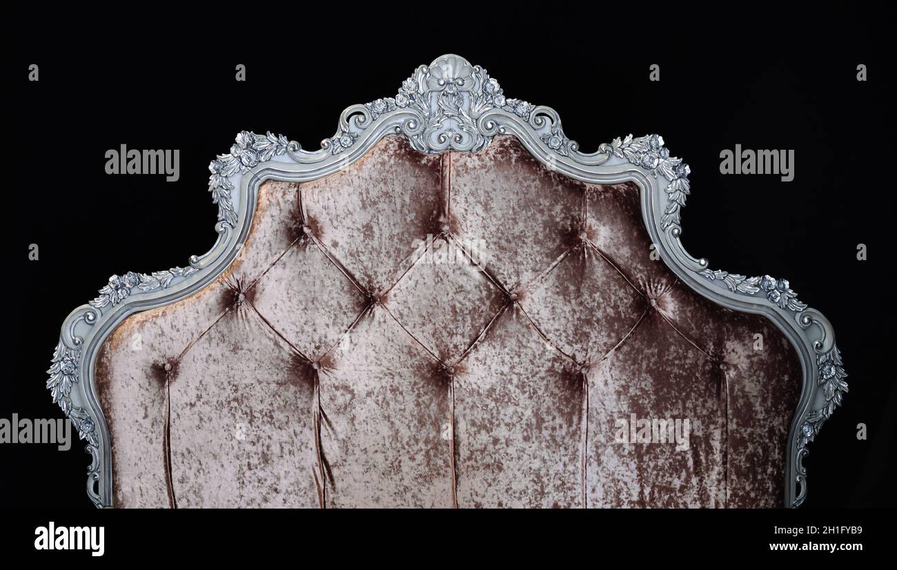 Back of a classic bed with carvings ornaments. Soft plush upholstery ...